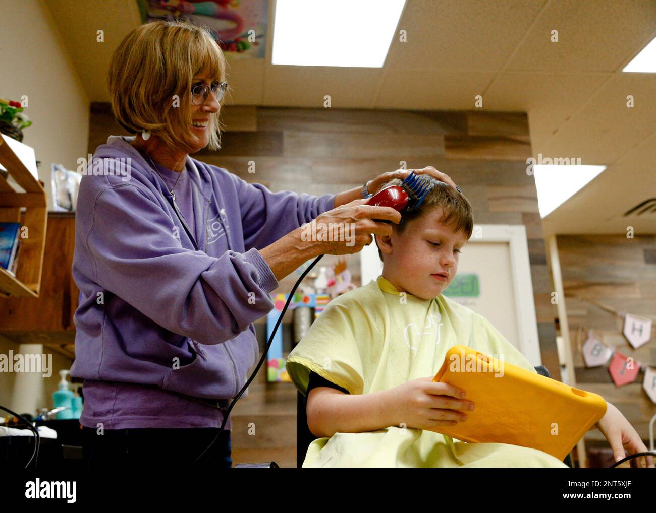 Judy Kreitzer gives 7-year-old Grayson Arledge, who suffers from autism ...