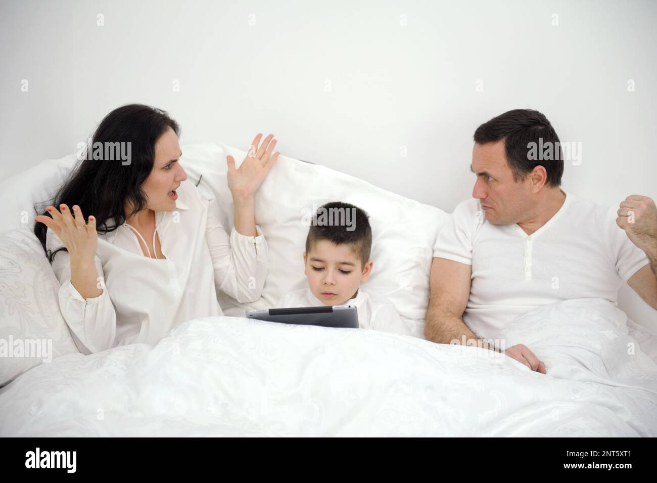 mother and father quarreling with child son holding tablet ignoring ...