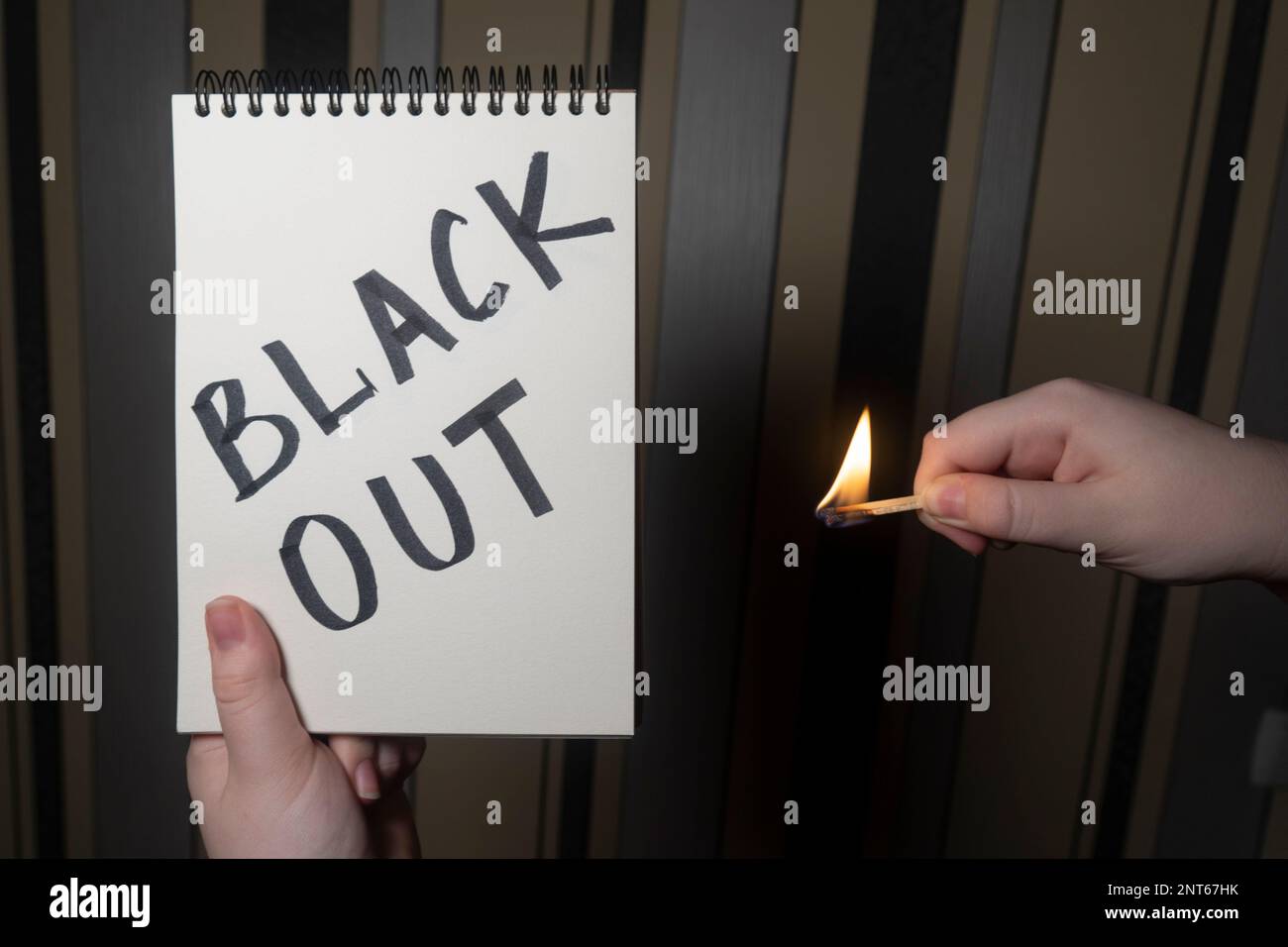 Notepad with the inscription "Blackout" in one hand and burning matches ...