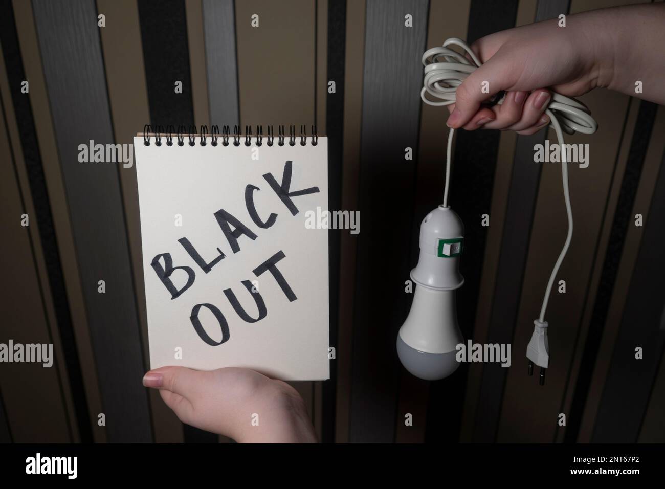 A notepad with the inscription "Blackout" in one hand and an electric ...
