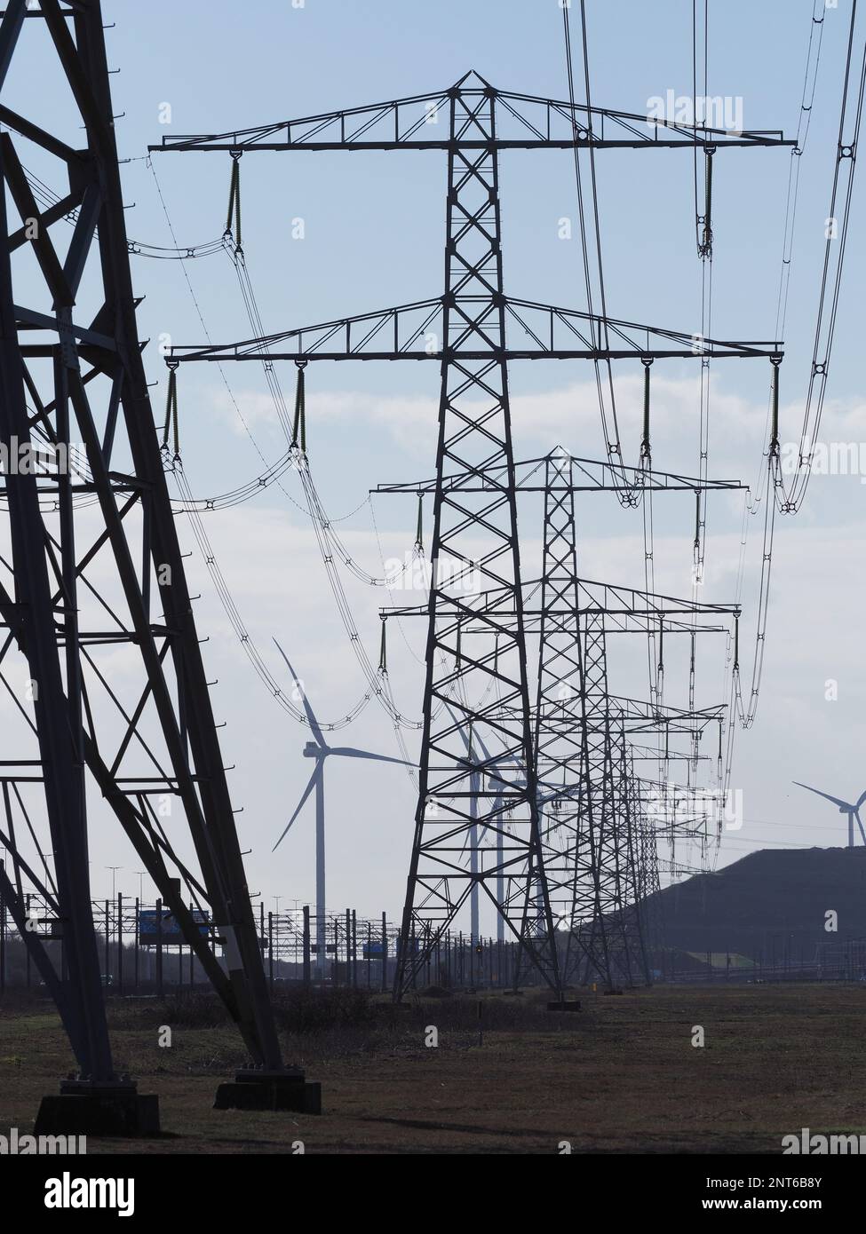 long line of high voltage power electicity lines masts towers in the ...