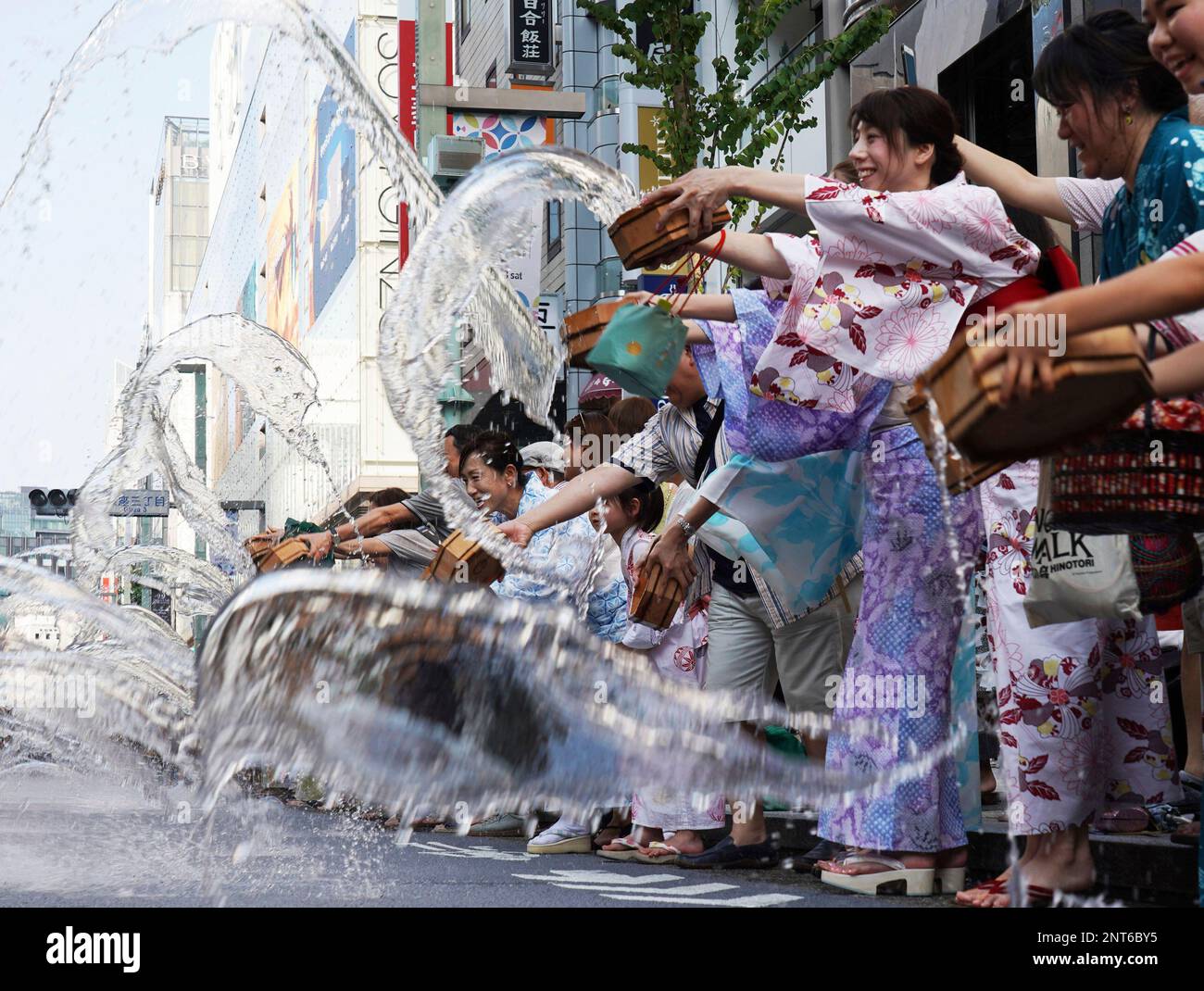 Participants wearing Yukata, Japanese cotton kimono, spray water in ...