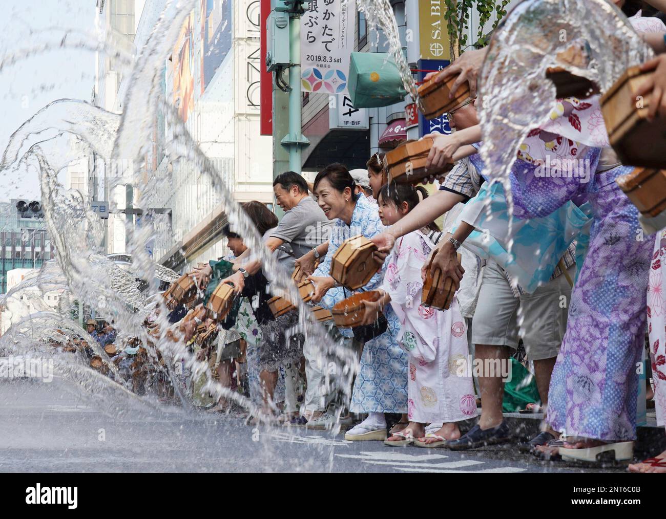 Participants wearing Yukata, Japanese cotton kimono, spray water in ...