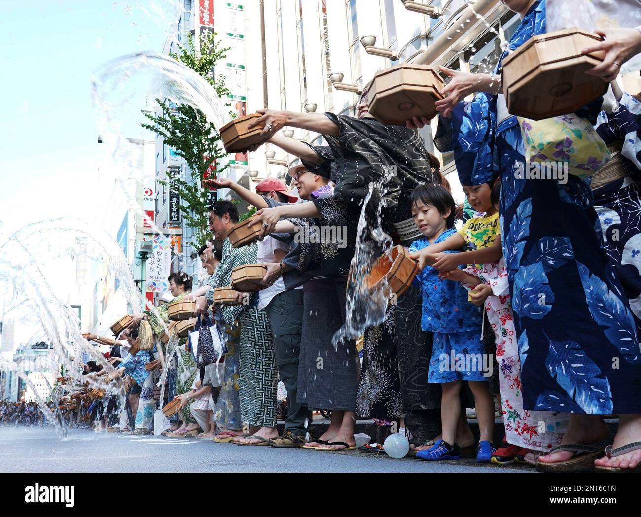 Participants wearing Yukata, Japanese cotton kimono, spray water in ...