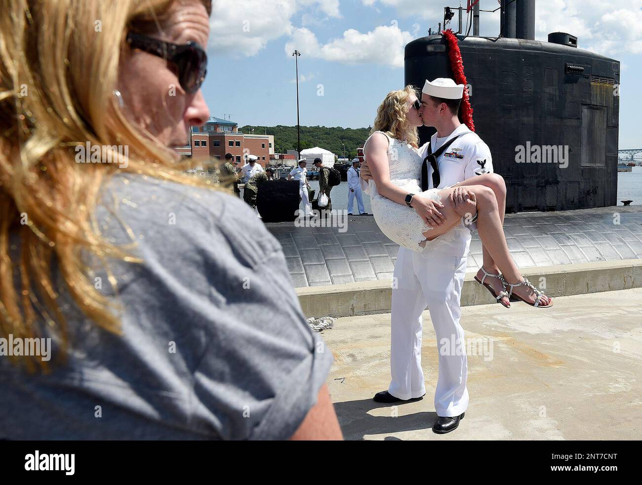 Evan Clements, an electronics technician, holds his girlfriend Caroline ...