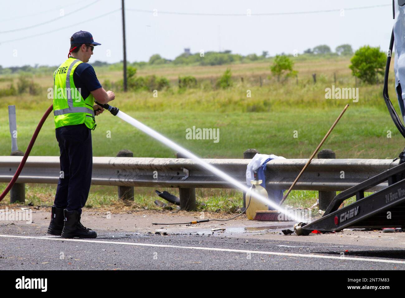 A firefighter with the Victoria Fire Department cleans the scene of a ...