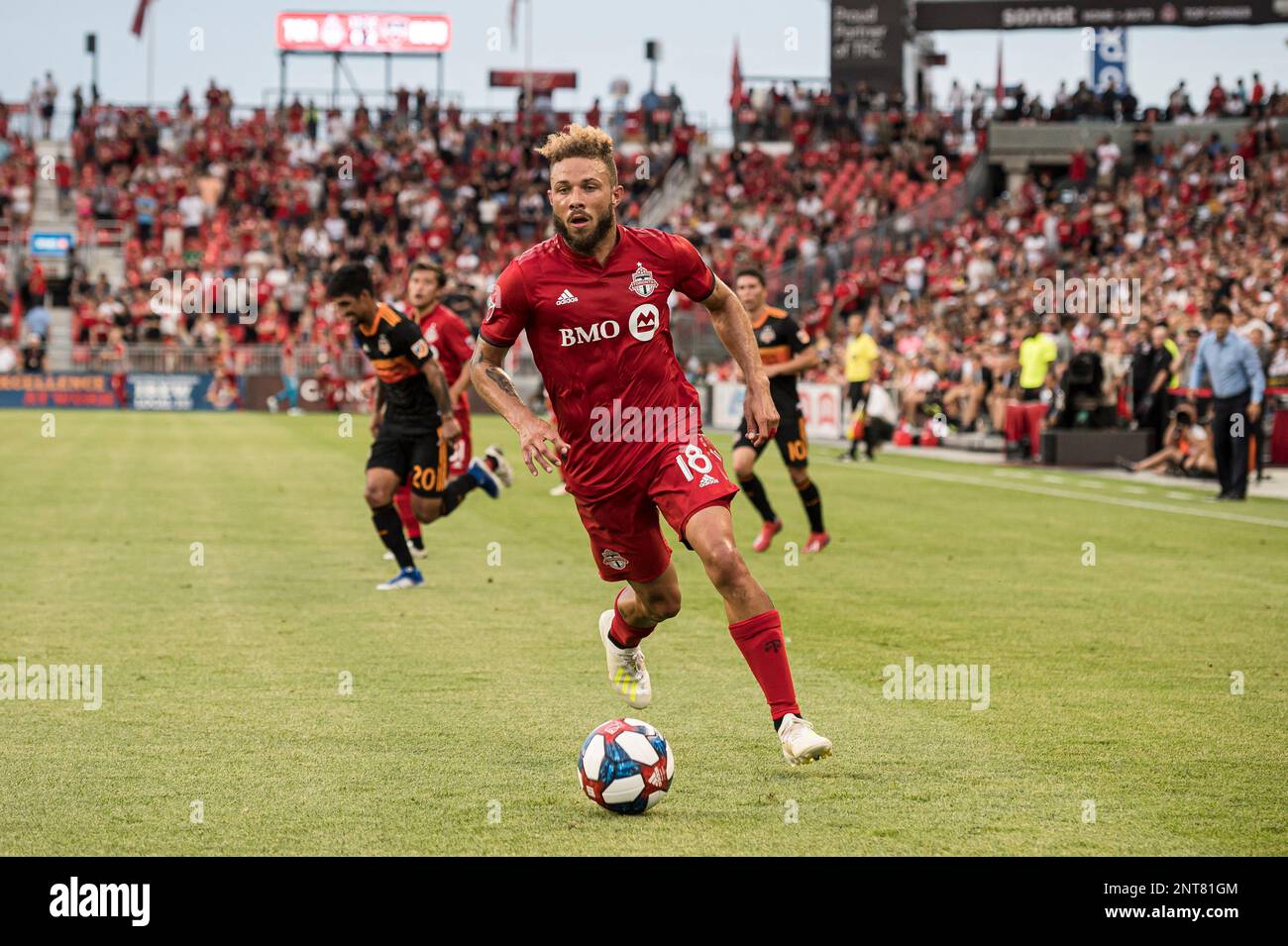 Toronto FC midfielder Nick DeLeon (18) dribbles the ball down field ...