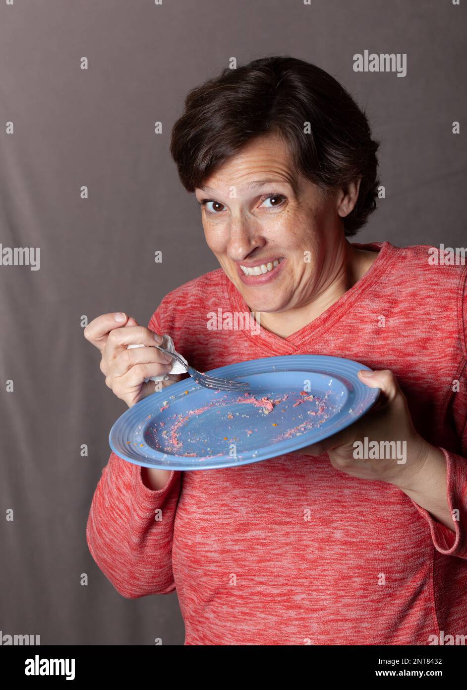 Older woman with an empty blue plate Stock Photo - Alamy