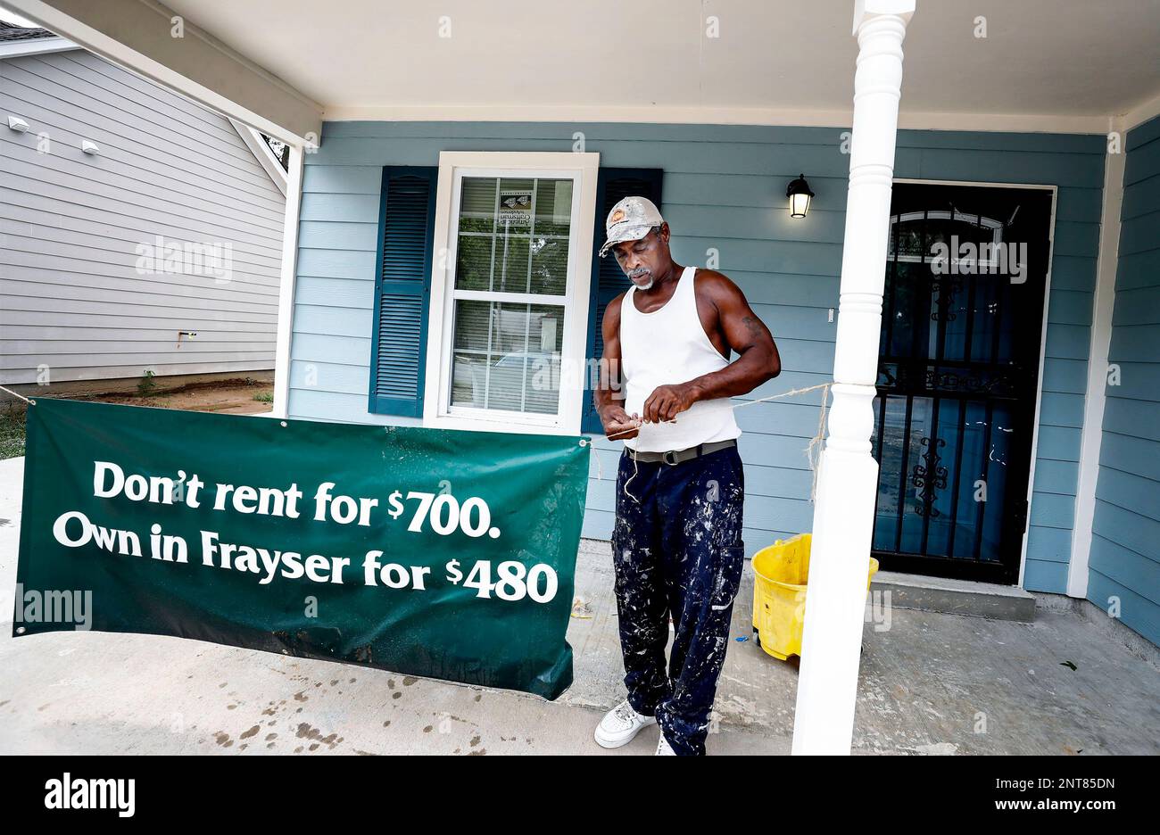 Contractor Ronnie Crawford hangs a sign outside a newly built home in ...