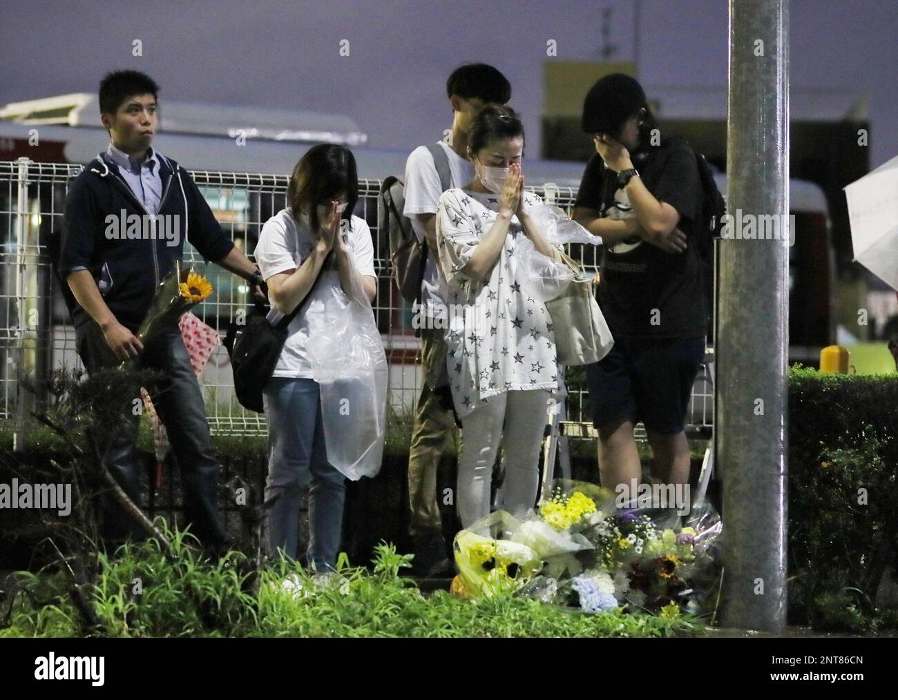 People place their hands together towards the fire site at Kyoto ...