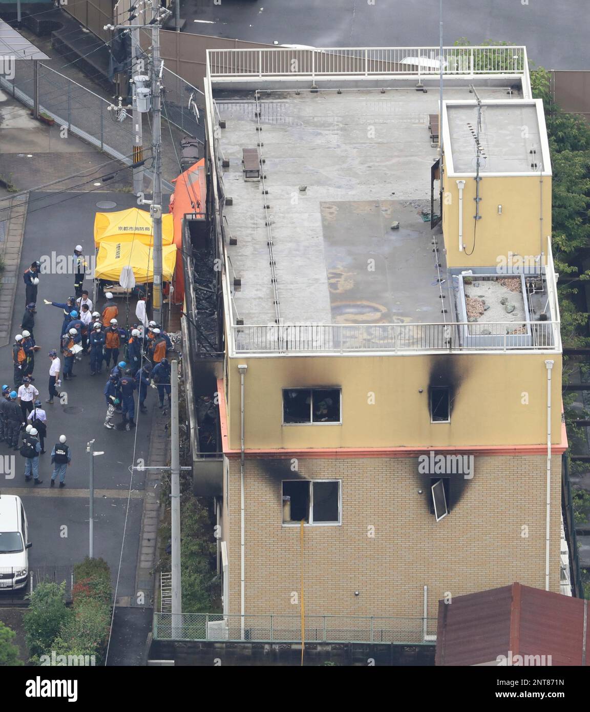 Police officers and fire fighters conduct an inspection of the fire ...