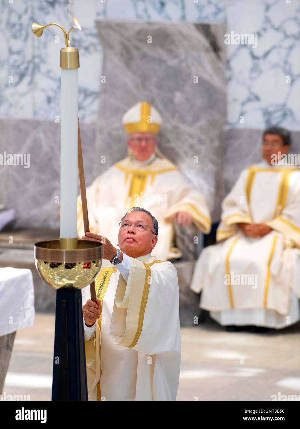 Deacon Joseph Khiet Nguyen lights a candle during the lighting of the ...