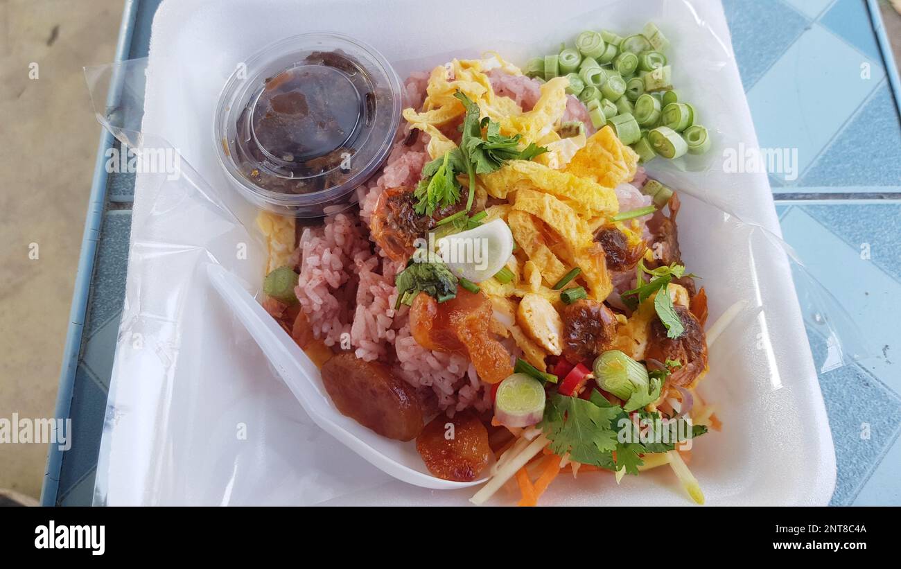 Shrimp paste fried rice with omelette, vegetables and meat in a ...