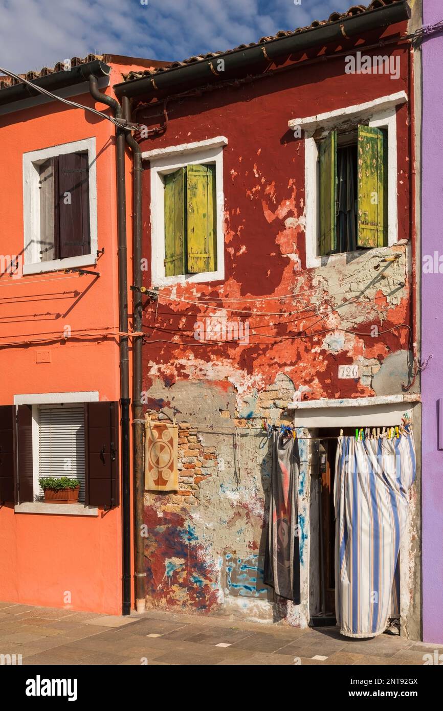 Old red stucco and brick house facade decorated with blue and white ...