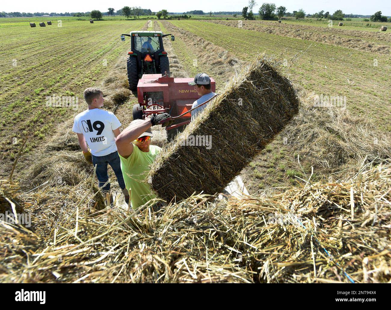 In this June 28, 2019 photo, Noah Sampson, 21, lifts a bale of hay ...