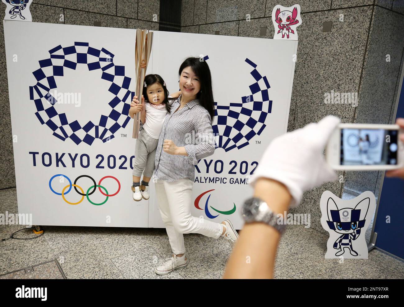 Visitors hold the 2020 Olympic and Paralympic relay torch at the Tokyo Metropolitan Government ...
