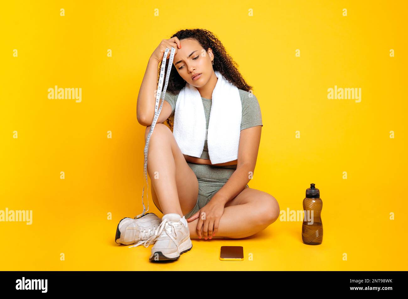 Full length exhausted mixed race young woman in sports outfit, with ...