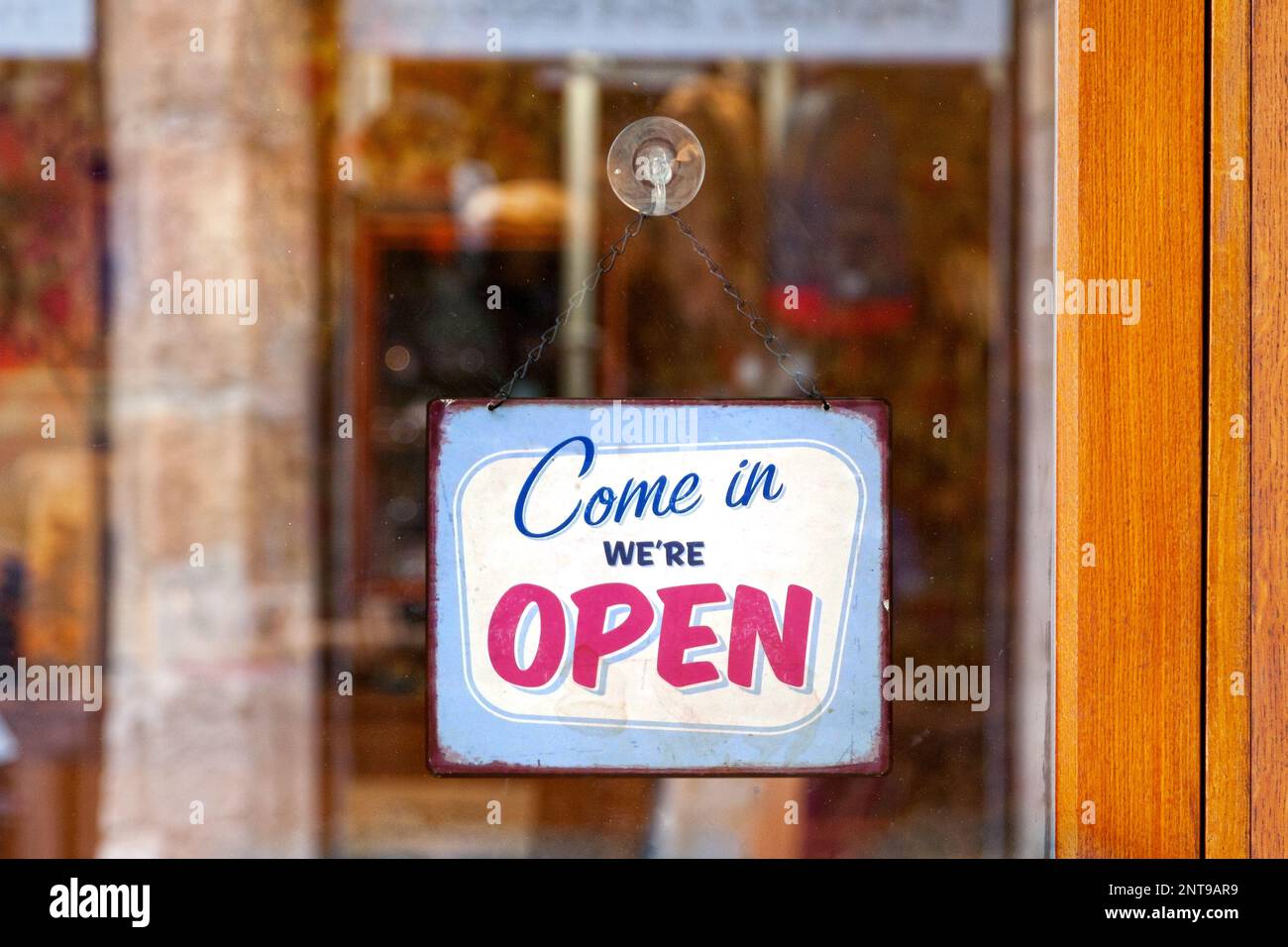 Close-up on an english open sign saying "Come in, we're open Stock ...