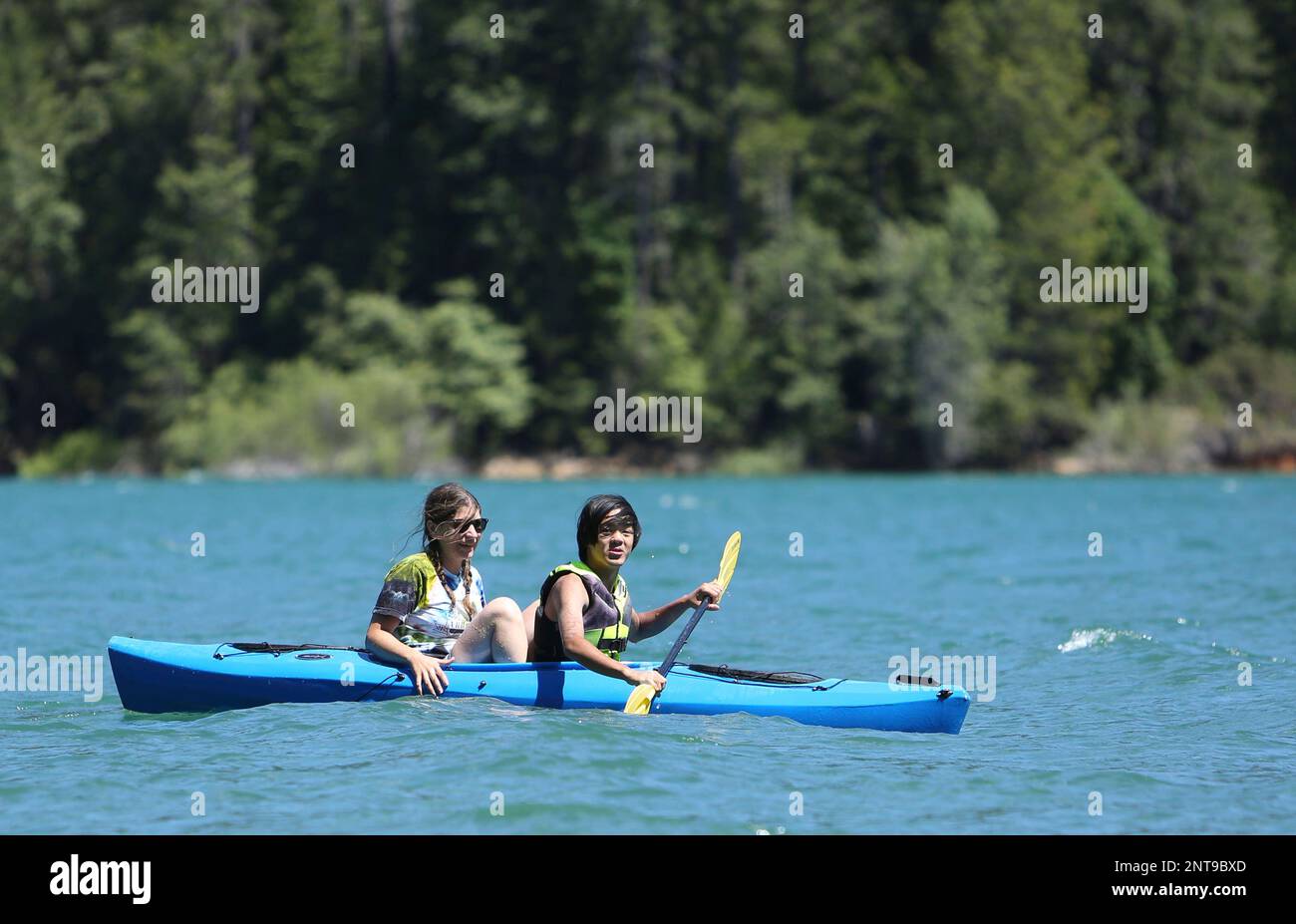 Student Thadeus Henderson paddles away in a kayak while para educator ...