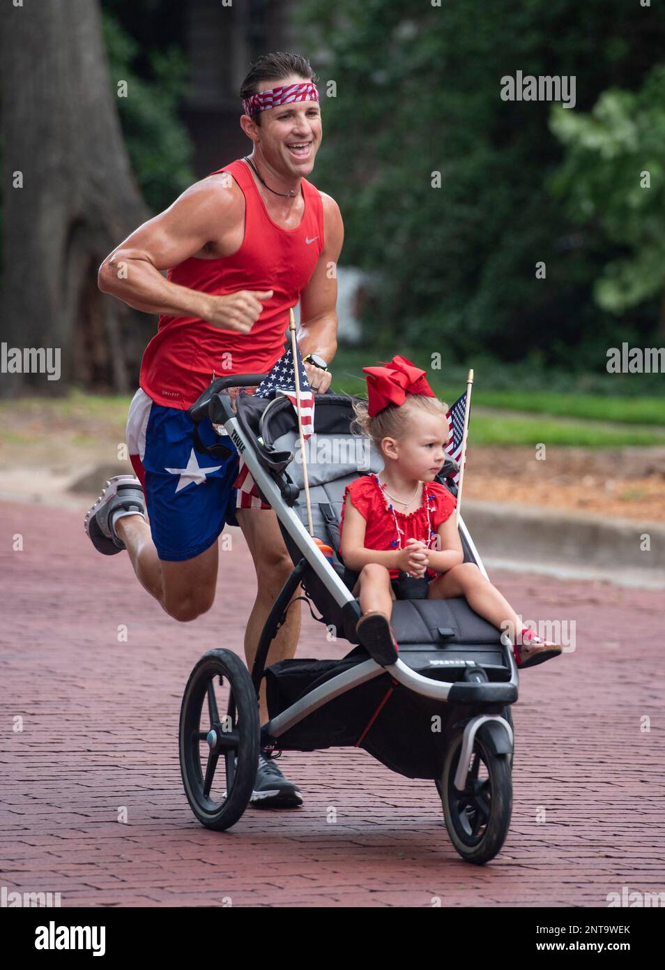Matt Meredith runs while pushing his daughter McKenna Meredith, 3, in a ...
