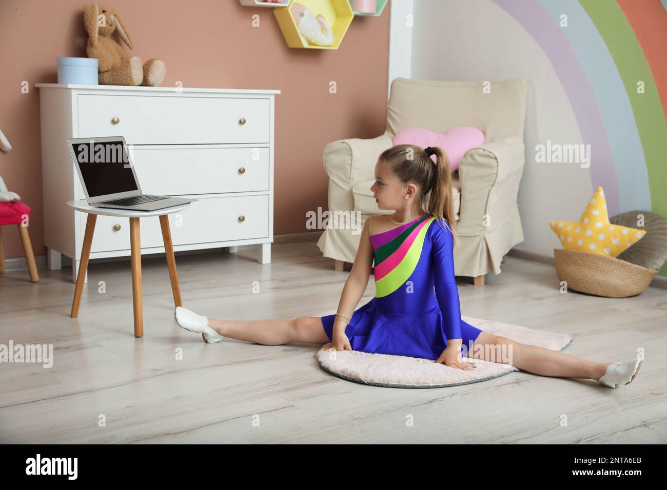 Cute little girl warming up before online dance class at home Stock ...