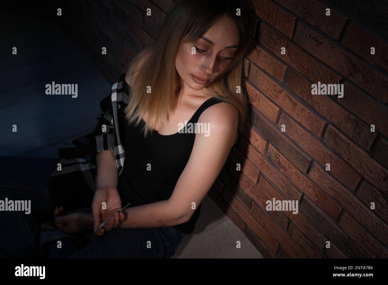 Overdosed drug addicted woman near brick wall Stock Photo - Alamy