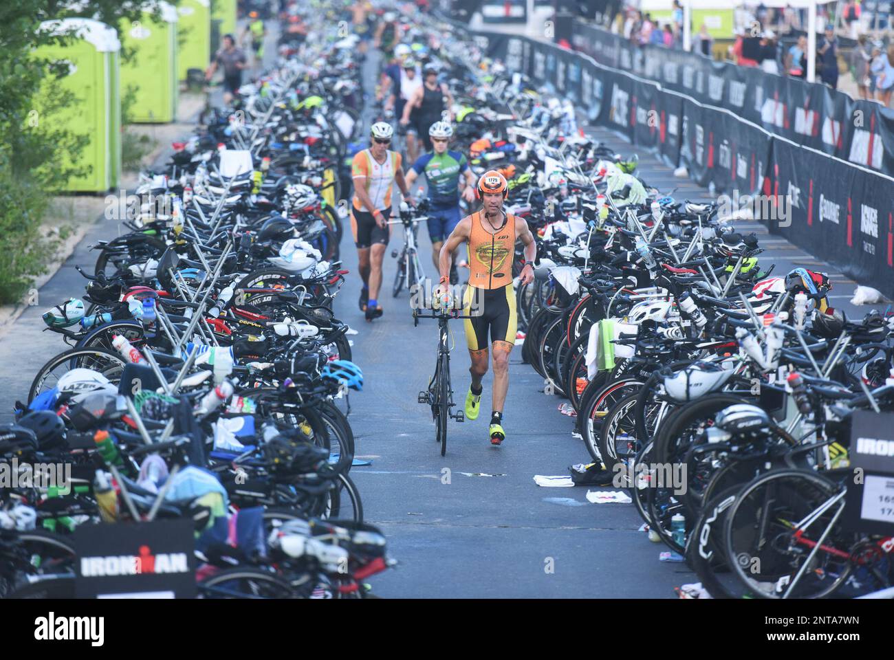 Athletes exit the bike transition area after completing the swim ...