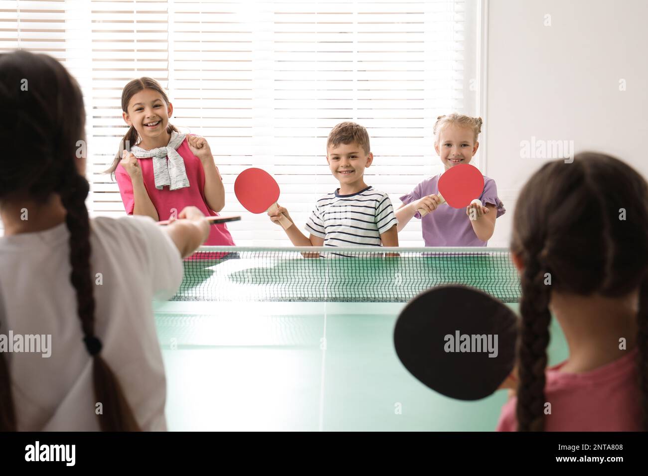 Cute happy children playing ping pong indoors Stock Photo - Alamy