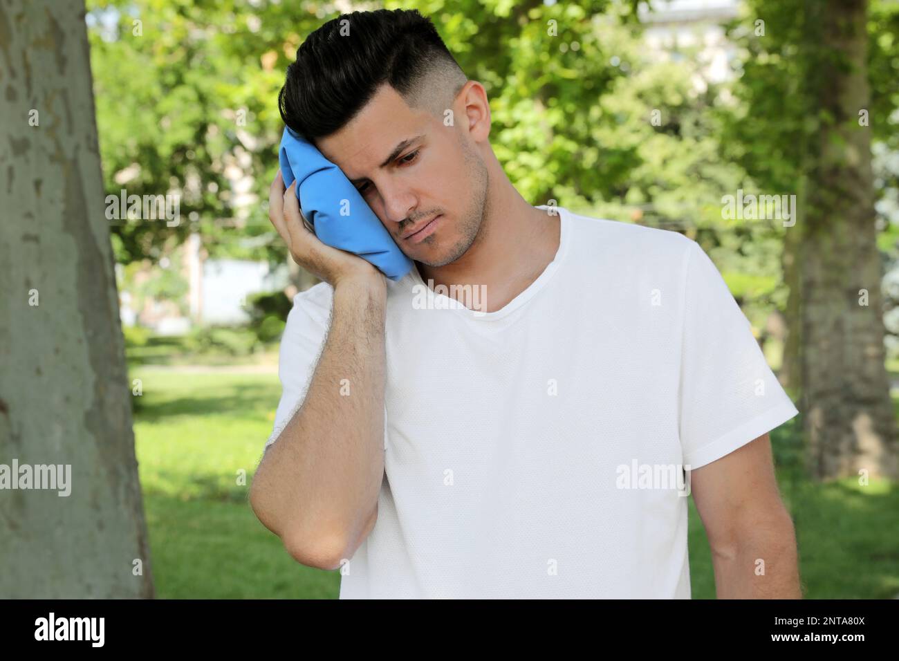 Man with cold pack suffering from heat stroke outdoors Stock Photo - Alamy