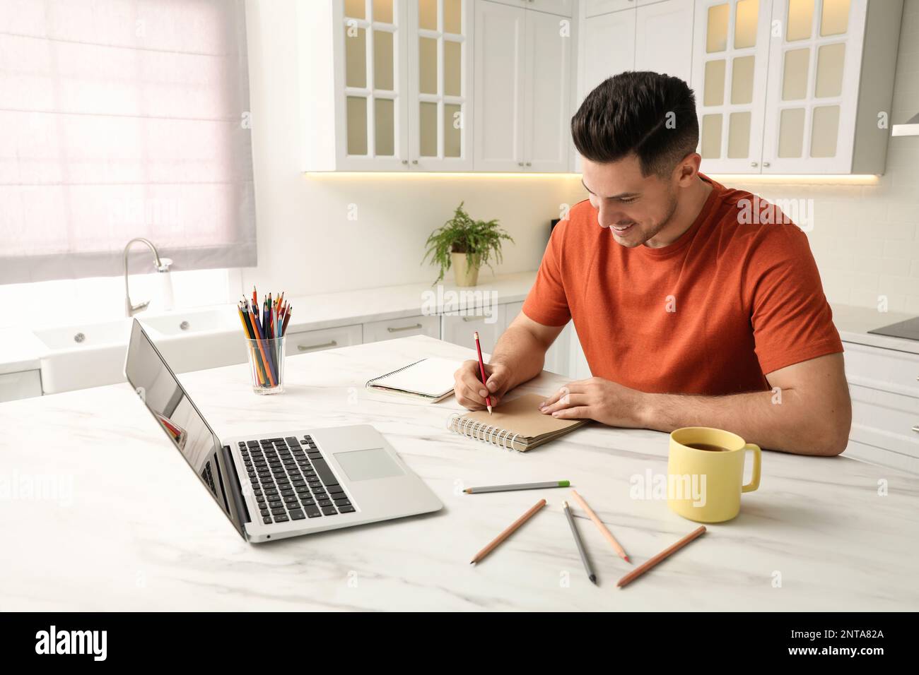 Man drawing in notebook at online lesson indoors. Distance learning ...