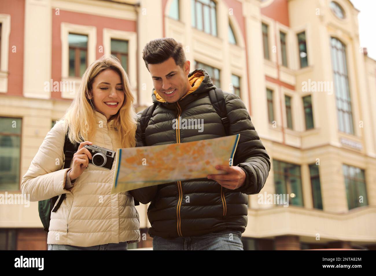 Couple of tourists with map and camera on city street Stock Photo - Alamy