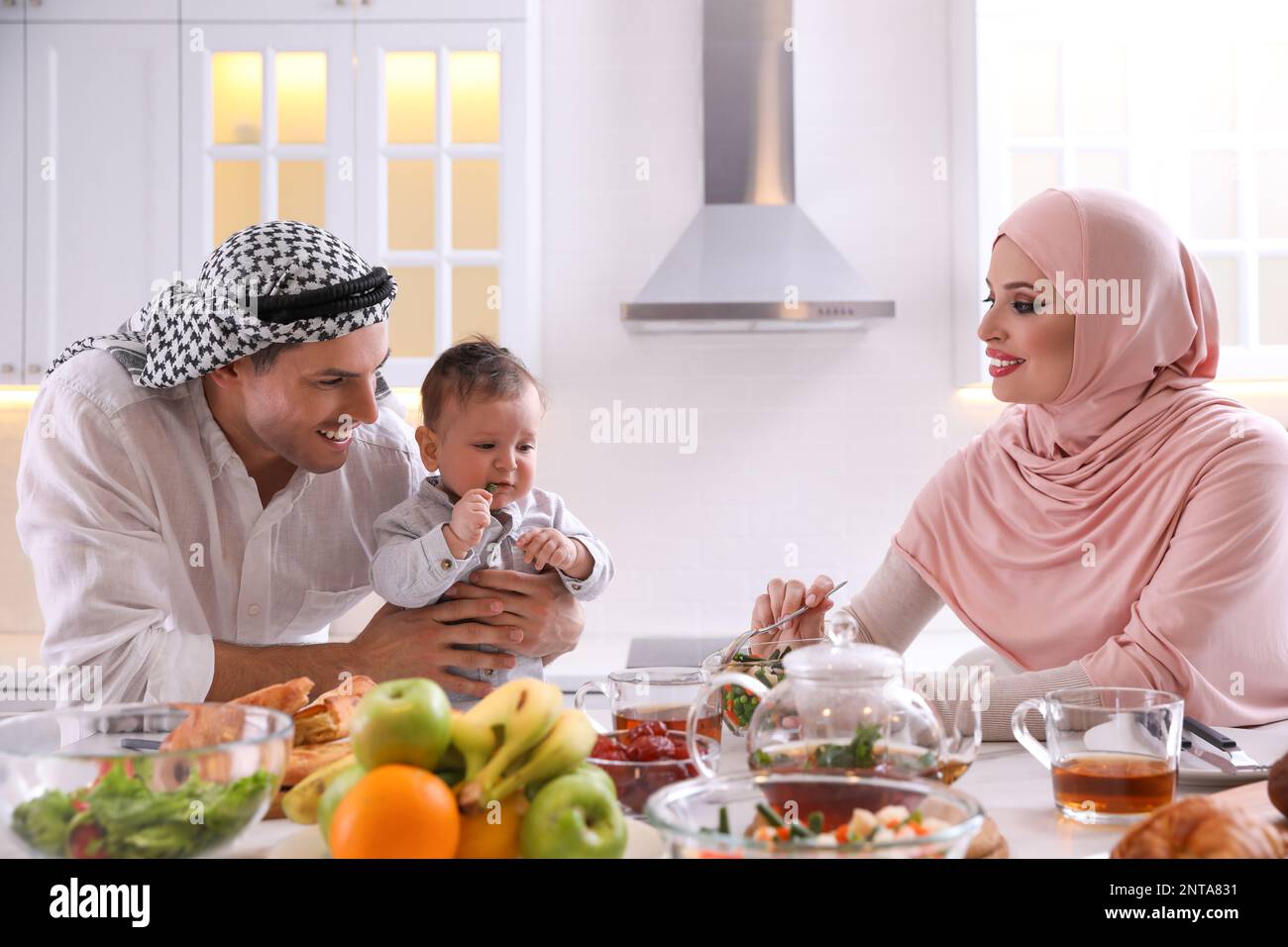 Happy Muslim family with little son at served table in kitchen Stock ...