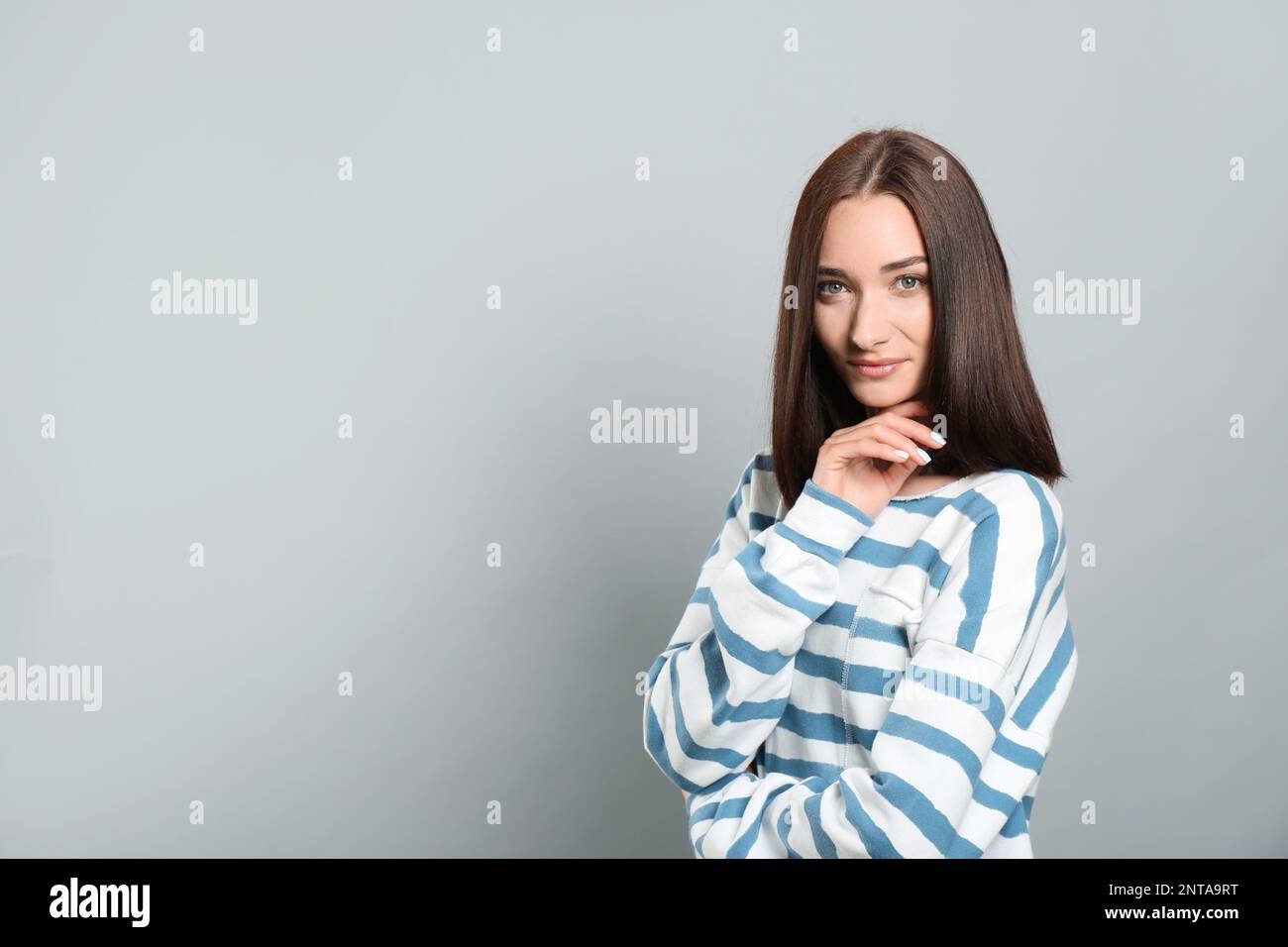 Portrait of pretty young woman with gorgeous chestnut hair on light ...