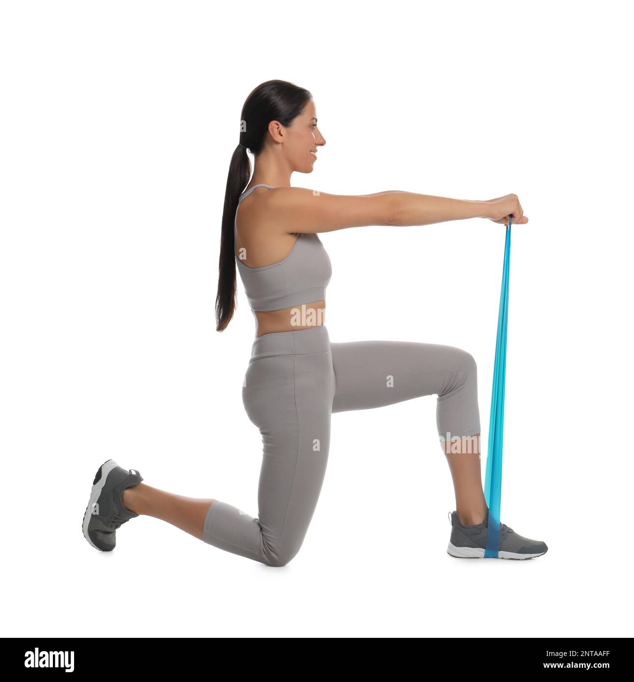 Woman doing sportive exercise with fitness elastic band on white ...