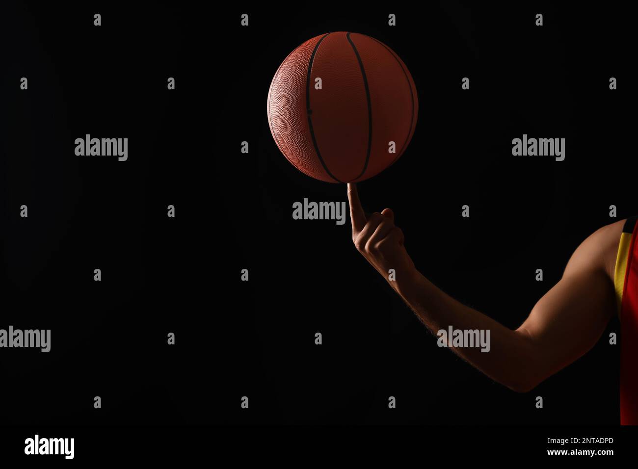 Basketball player with spinning ball on black background, closeup ...
