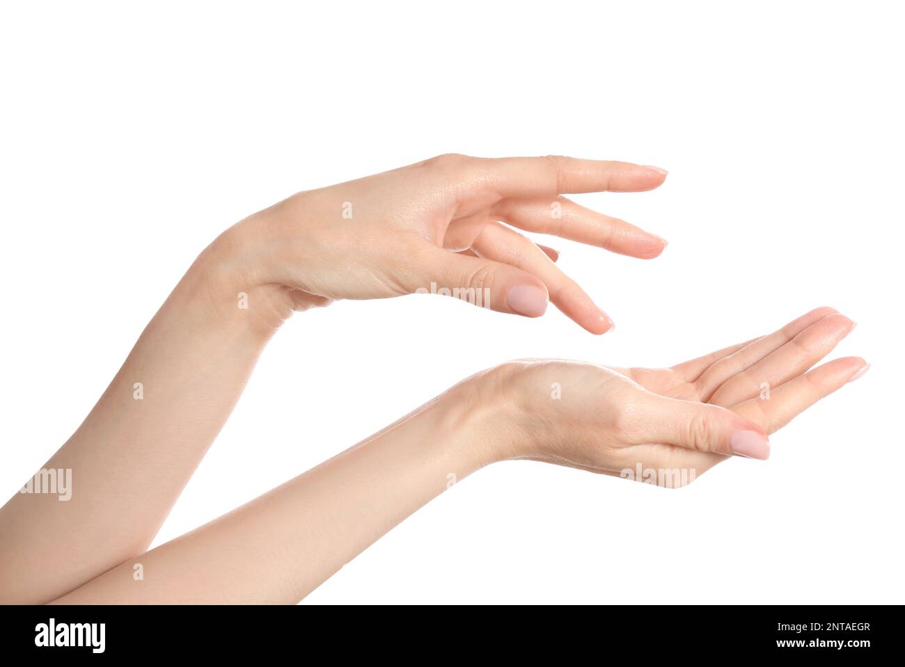 Young woman applying something onto her hands on white background ...