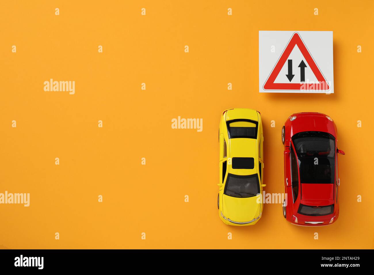 Toy cars and road sign Two Way Direction on yellow background, flat lay ...