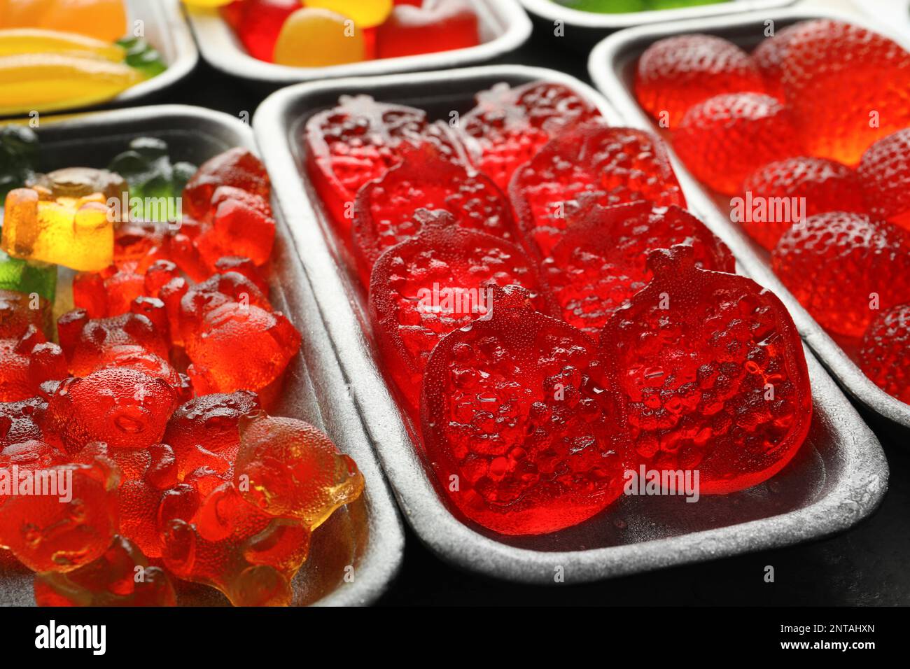 Different delicious gummy candies in containers, closeup Stock Photo ...