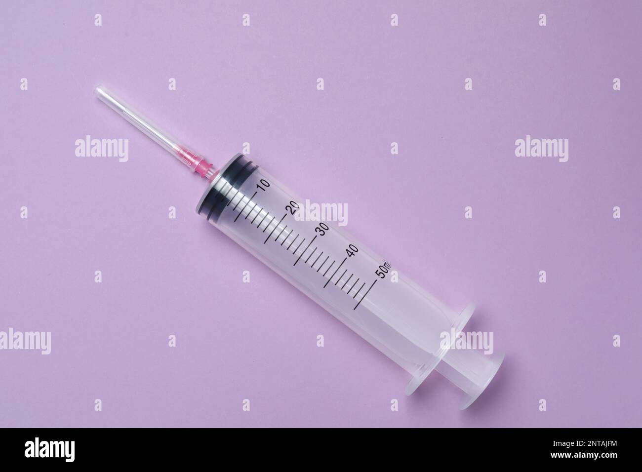 Disposable syringe with needle on violet background, top view Stock ...