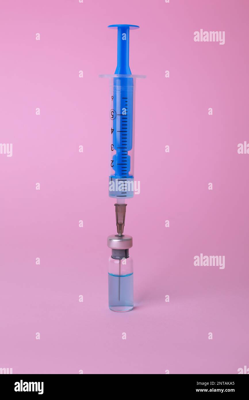Disposable syringe with needle and vial on pink background Stock Photo ...