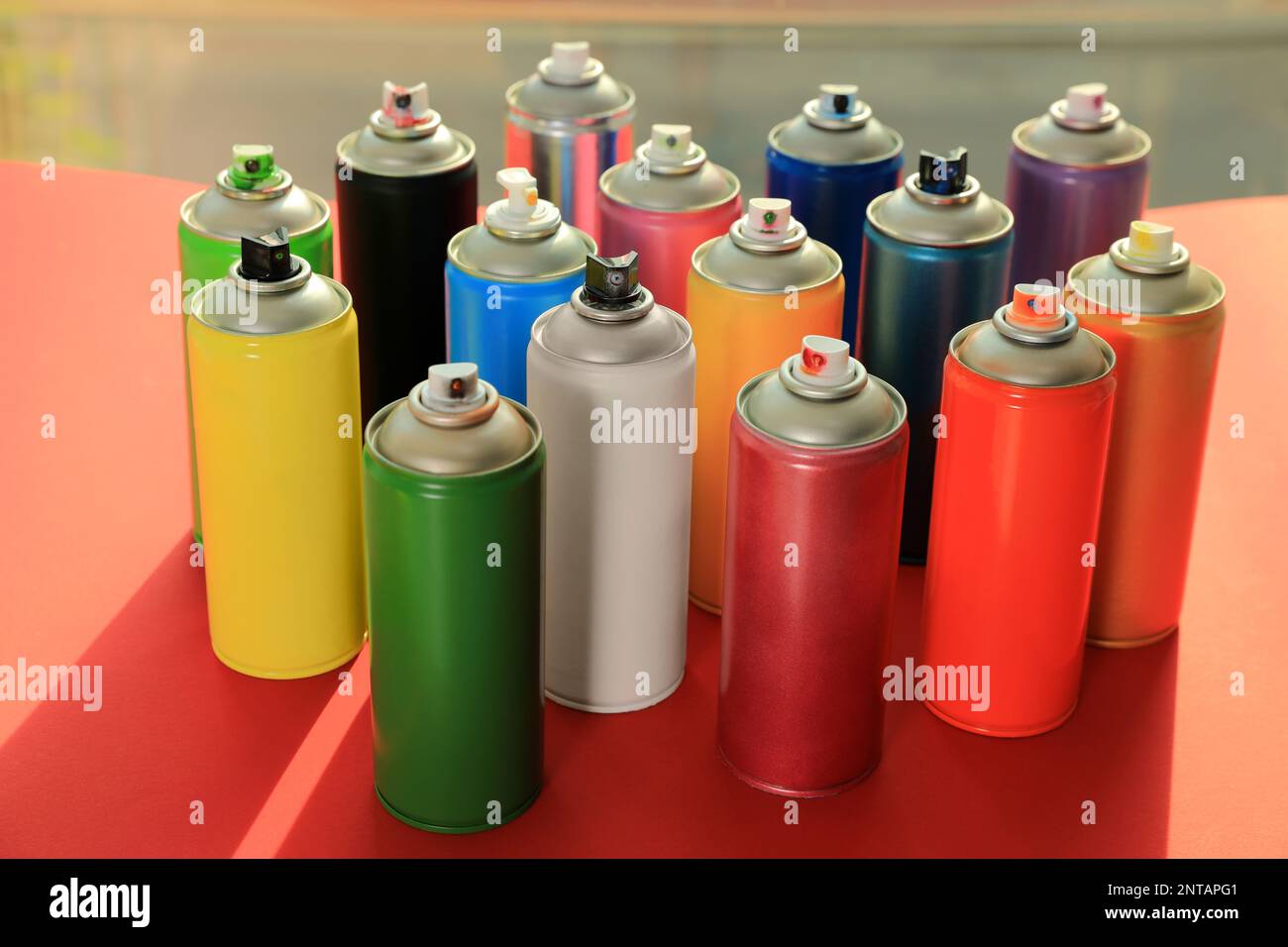 Cans of different graffiti spray paints on red table near window Stock ...