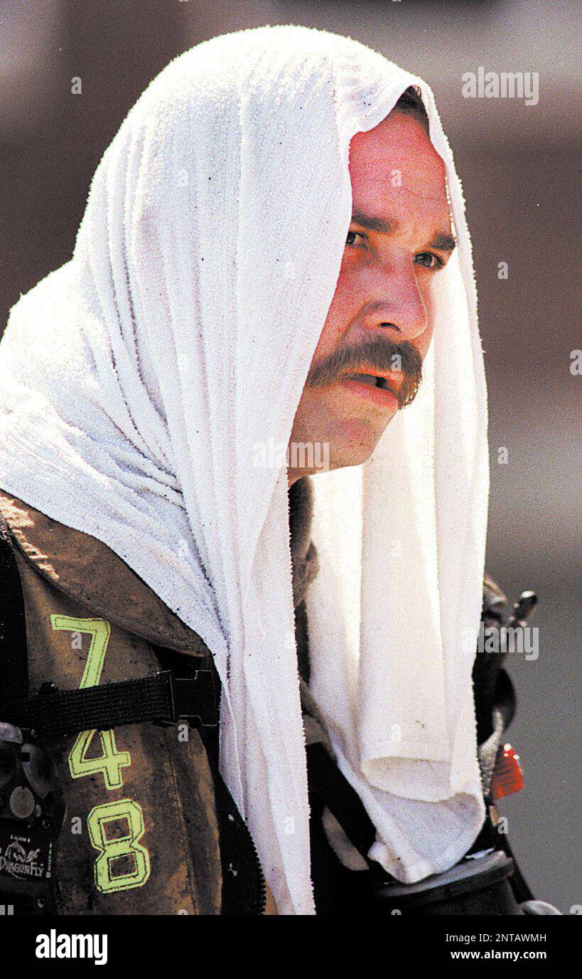 Firefighter Jimmy Henderson tries to cool down with a wet towel while ...