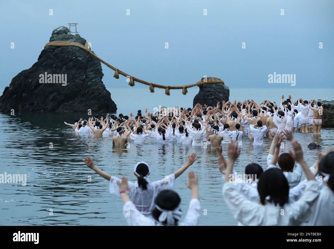 People facing Meoto Iwa, Wedded Rocks, purify with sea water during the ...