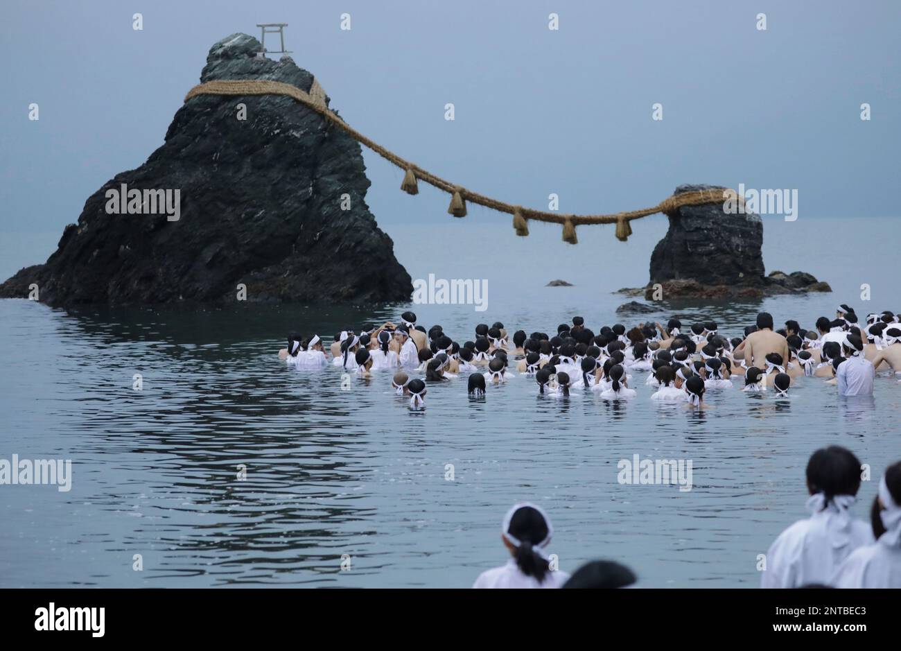 People facing Meoto Iwa, Wedded Rocks, purify with sea water during the ...