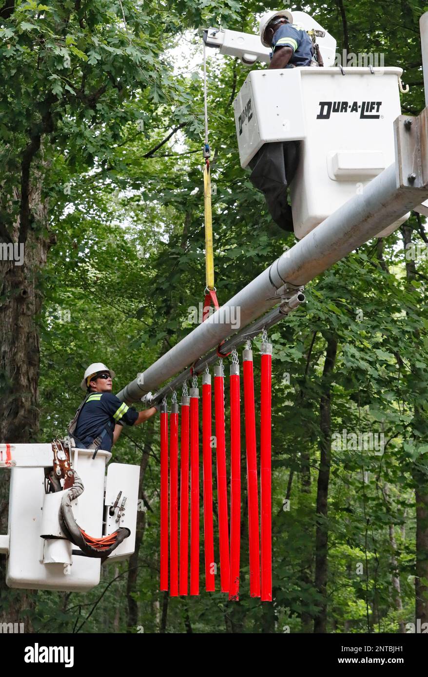 Cobb DOT workers install the mast arms before lowering the PVC pipes to ...