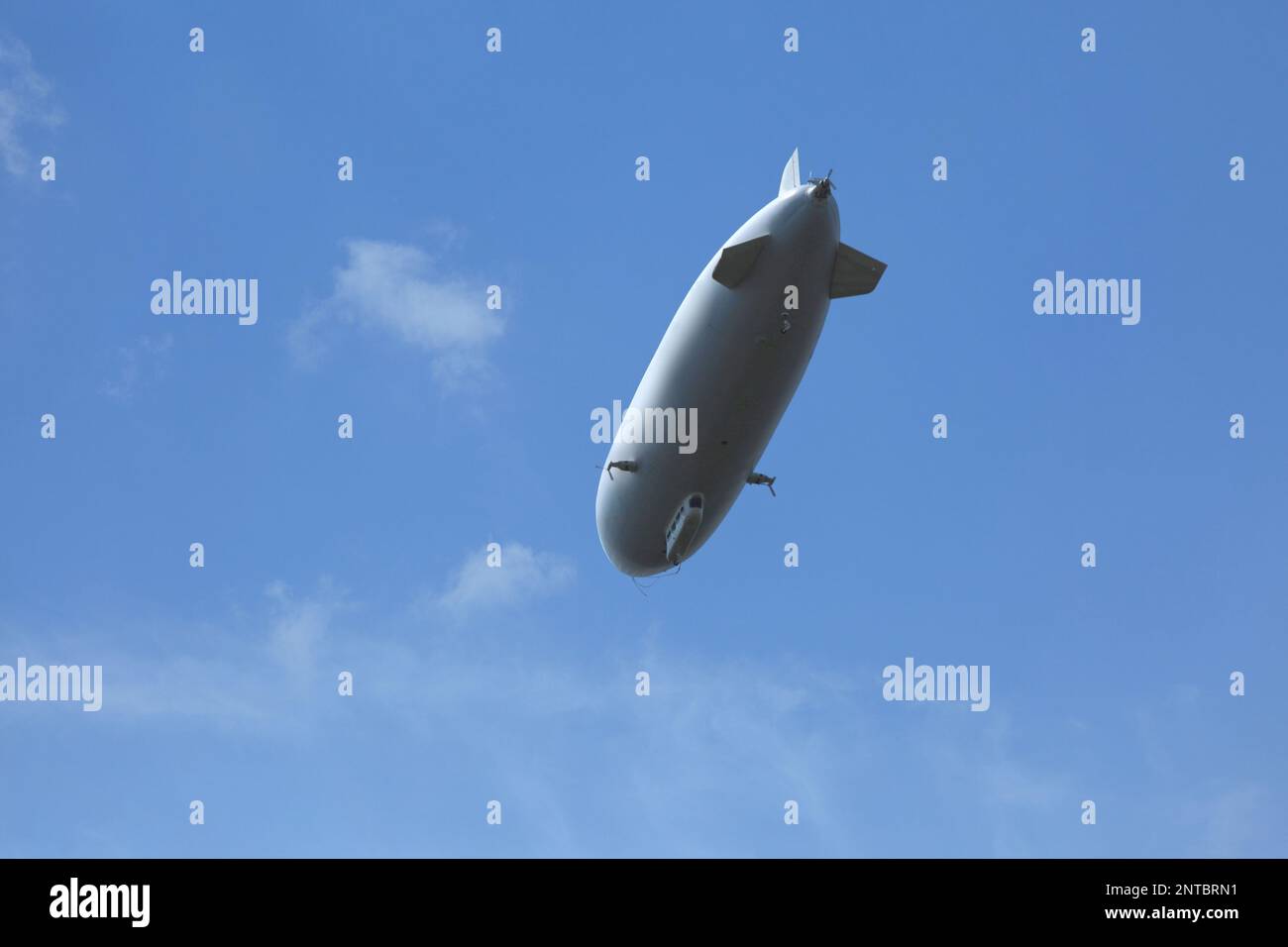 A low angle view of a white zeppelin in the blue clear sky Stock Photo ...