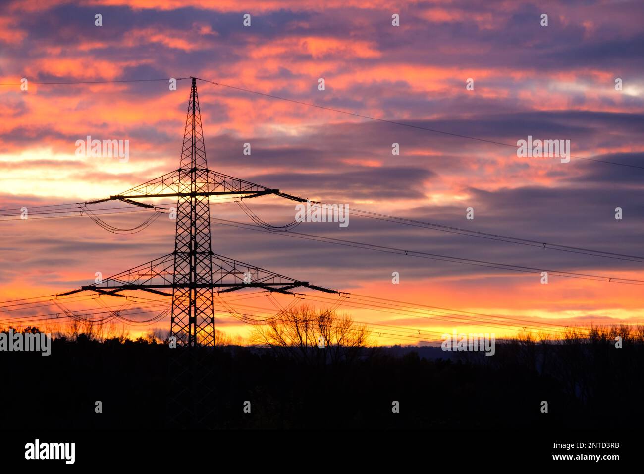 High-voltage pylon against sunset Fire-red sky Stock Photo - Alamy