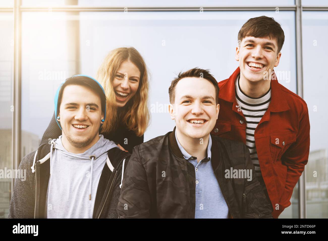 group of four young teenage friends having fun and laughing together ...