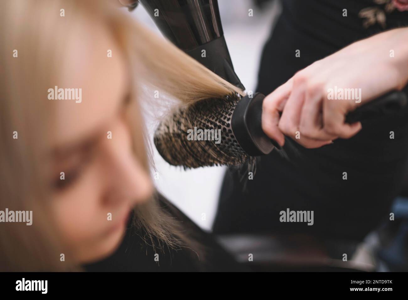 crop hairstylist setting hair with brush. Beautiful photo Stock Photo ...