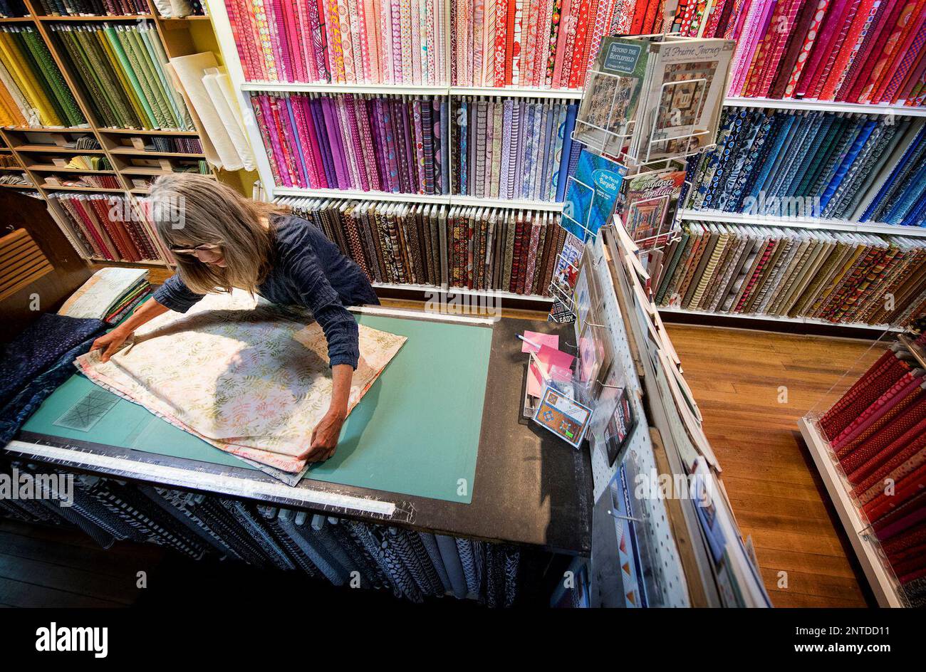 Cosmic Cow co-owner Roxann O'Hare organizes fabric she's cut up for a ...